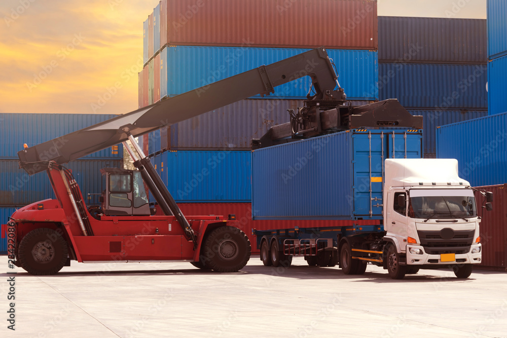 Reach stacker is taking blue 40' high cube container to put on haulage ...