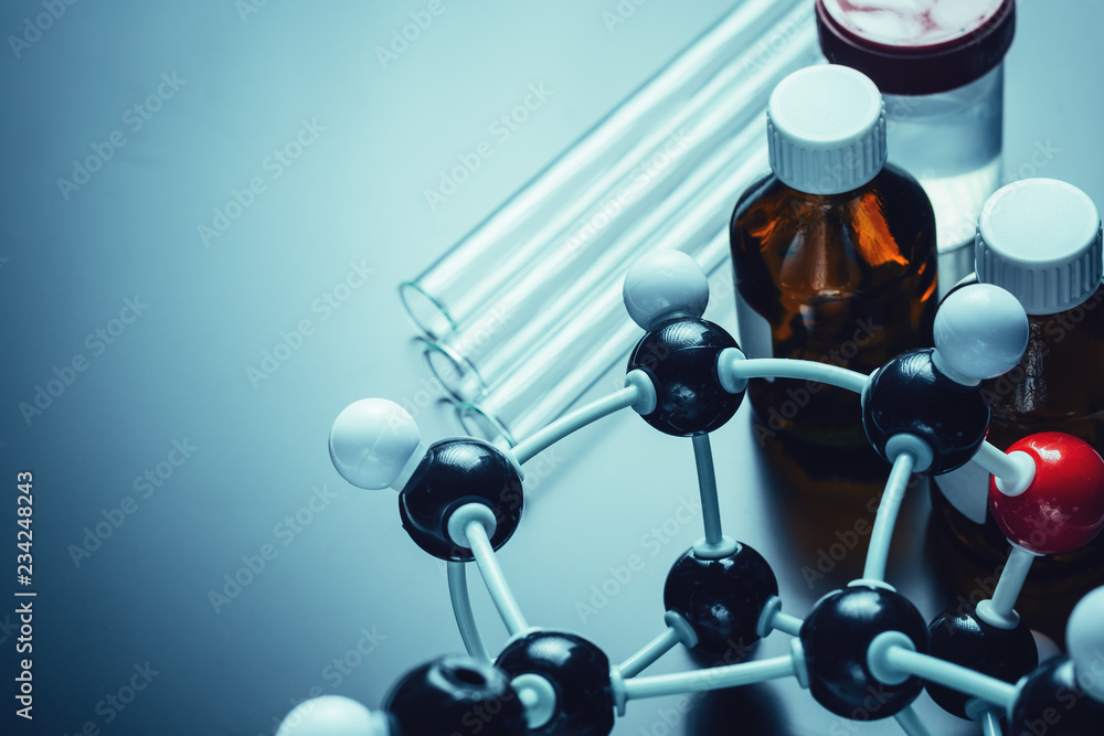 molecular formula and laboratory equipment on a dark background with ...