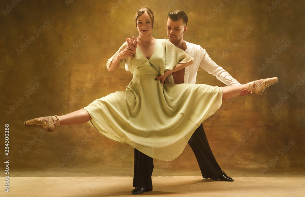 Flexible young modern couple dancing tango in studio. Fashion portrait ...