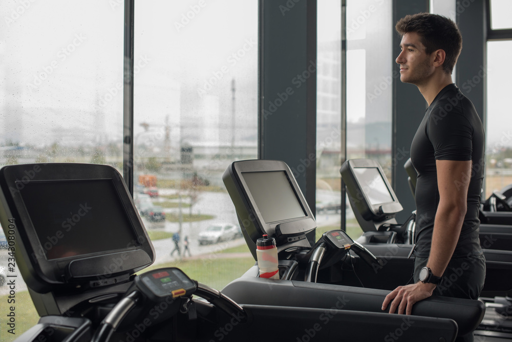 Man standing on a running machine looking out of a window Stock Photo ...