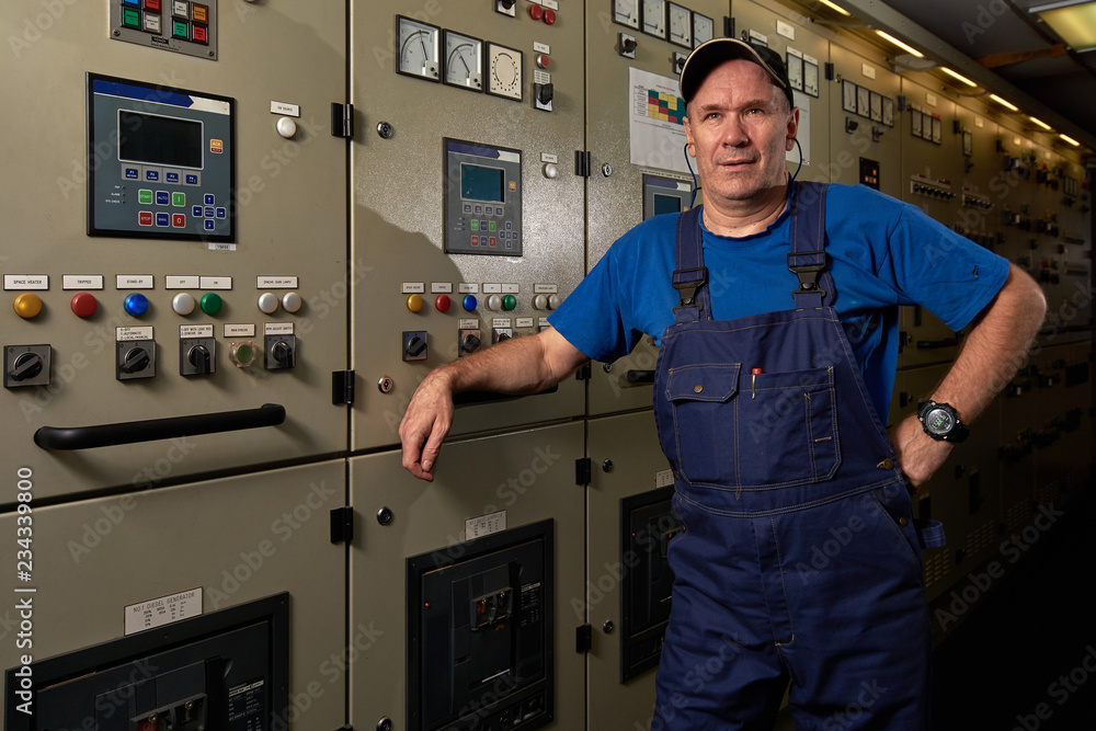 Proud and happy mechanic / chief engineer, posing with his arms crossed ...