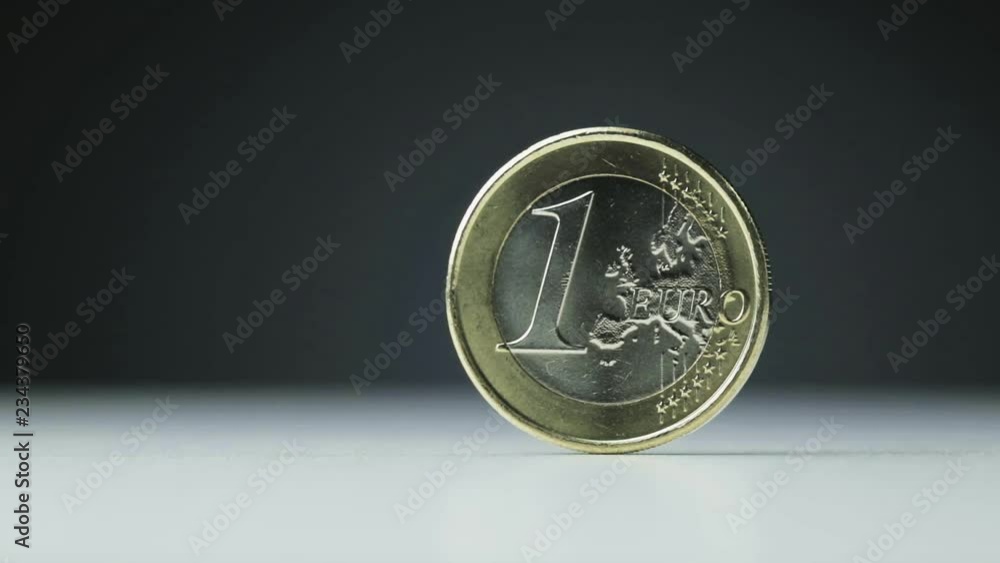Extreme closeup footage of a one Euro coin spinning slowly on its axis ...