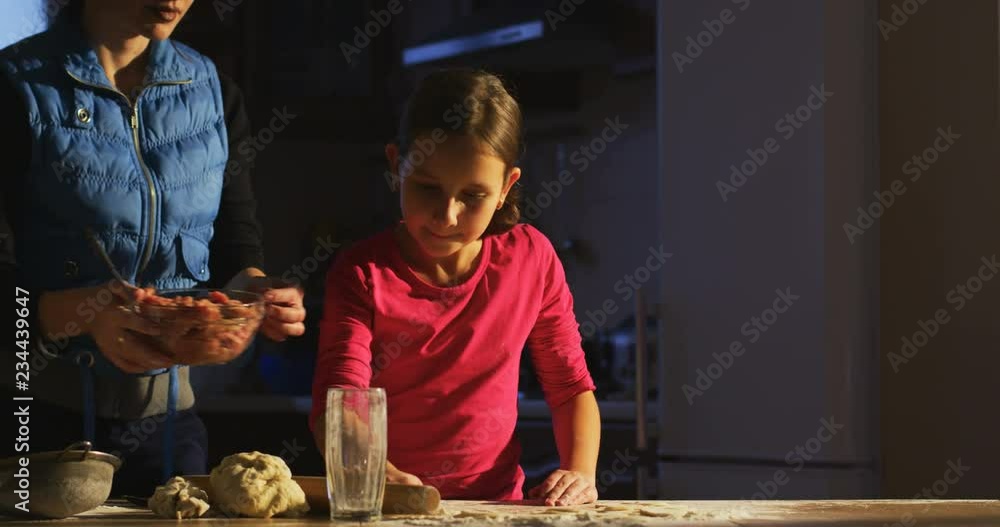 Little girl at the table ready to cook with mother learning little chef ...