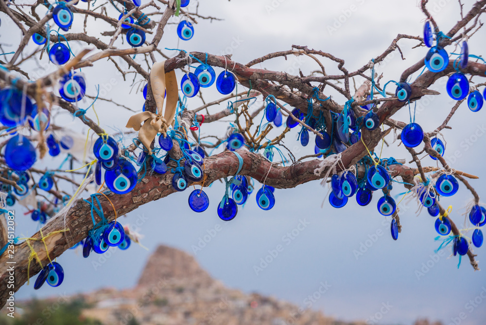 Evil eye in tree behind Uchisar Castle in Cappadocia, Uchisar, Turkey ...