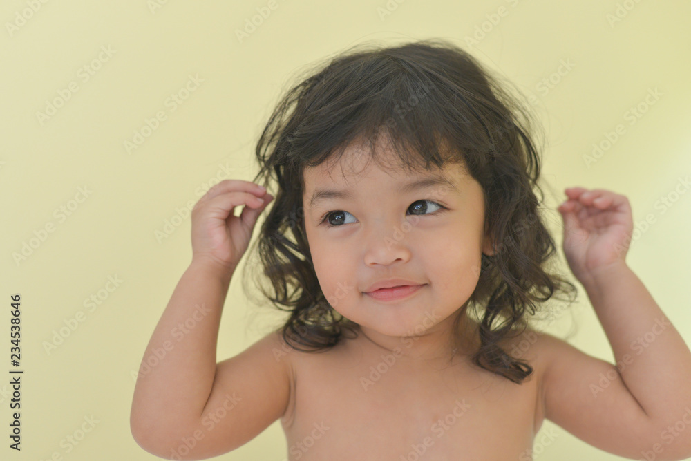 Portrait of a smiling happy little cute Asian child girl showing her ...