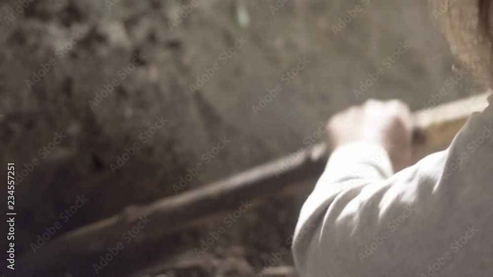 Vidéo Stock A man like Jesus Christ is digging a hole in the dungeon, a ...