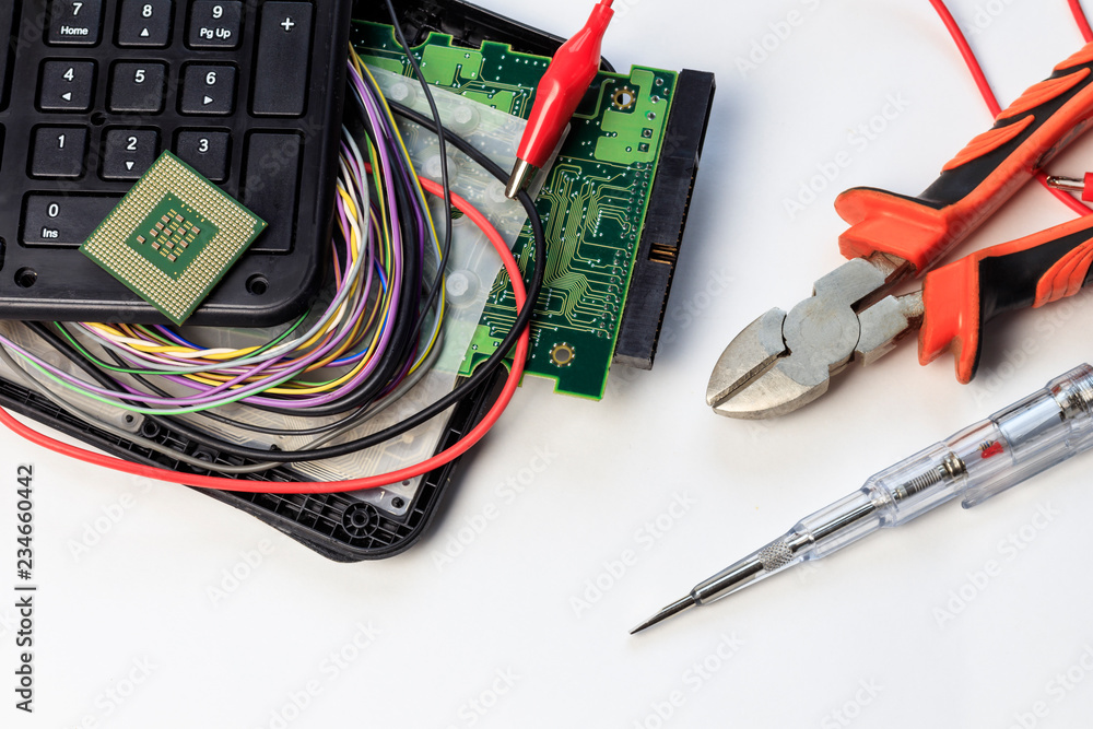 A broken laptop and wire sticking out of it on it on a white background ...