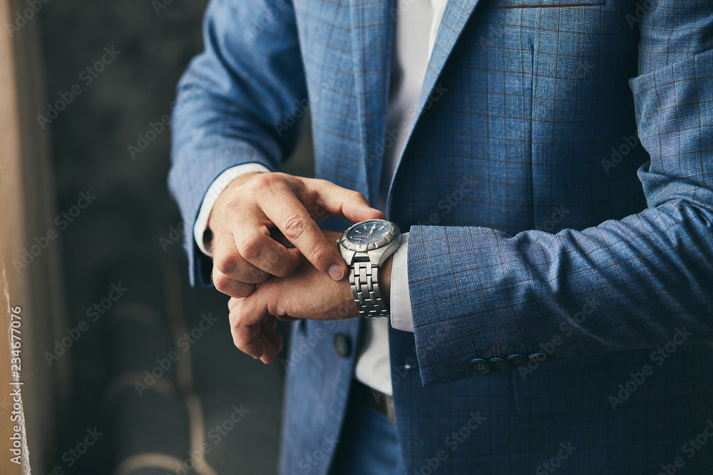 businessman checking time on his wrist watch, man putting clock on hand ...