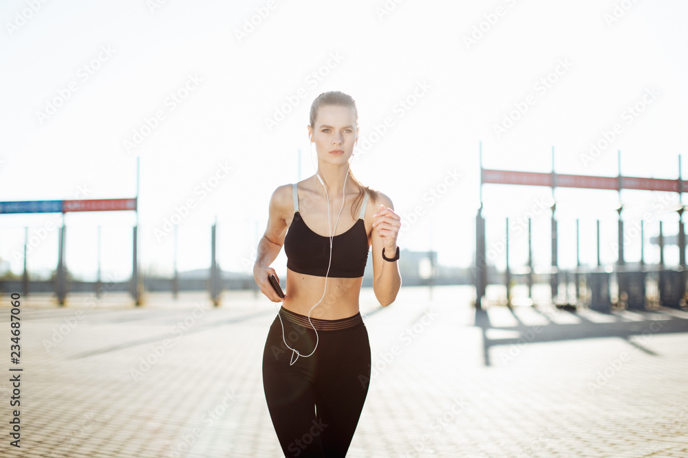 Early morning workout. Happy Beautiful women running in the headphones ...