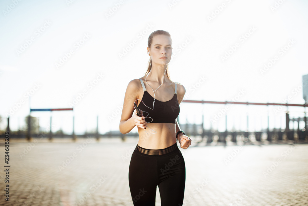 Early morning workout. Happy Beautiful women running in the headphones ...