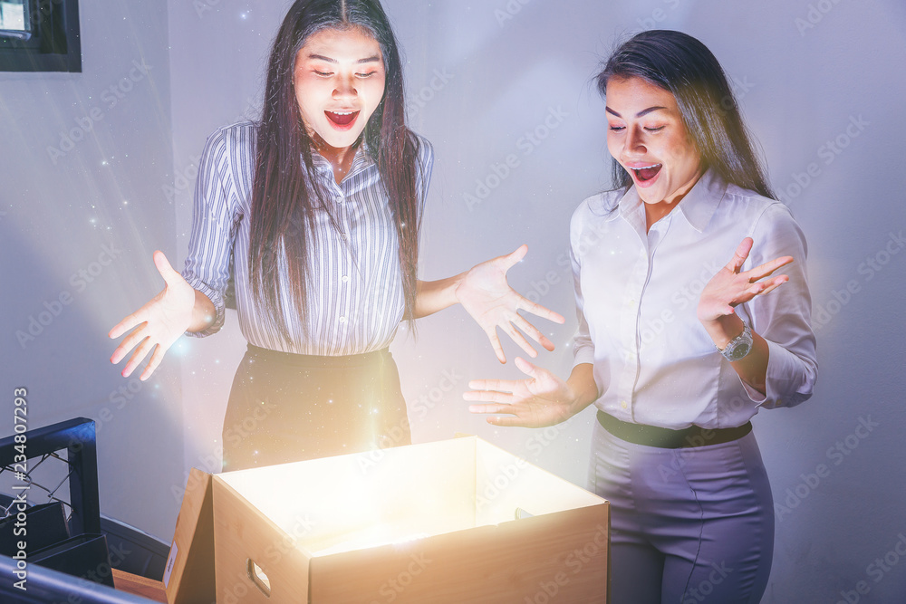 Businesswomen opening cardboard box with surprise emotion for something ...