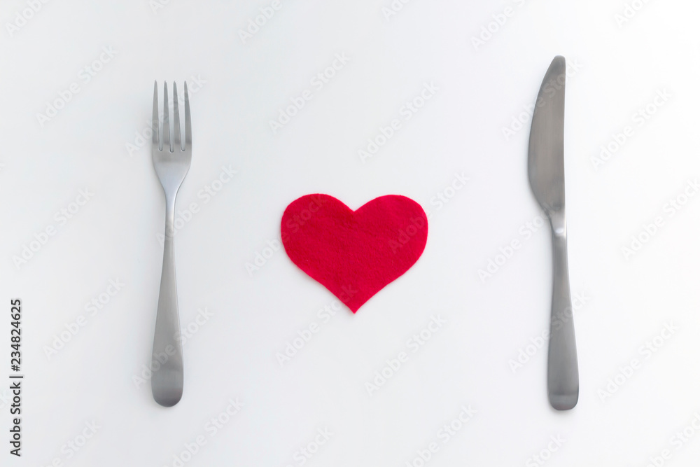 Fork, knife and heart cutted from red felt om the white background. Top ...