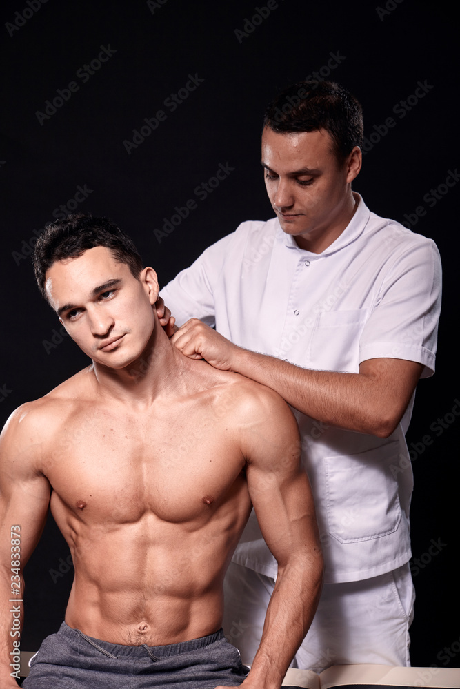 two young man, 20-29 years old, sports physiotherapy indoors in studio ...