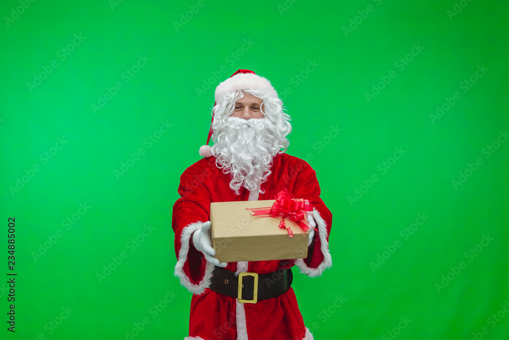 Merry Christmas. Santa Claus in a red suit gives out gifts in boxes on ...