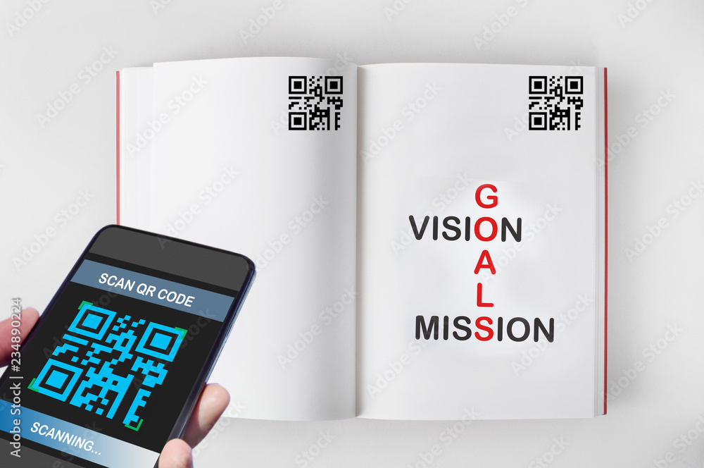 Hand holding smartphone with scanning QR code on book screen with words ...