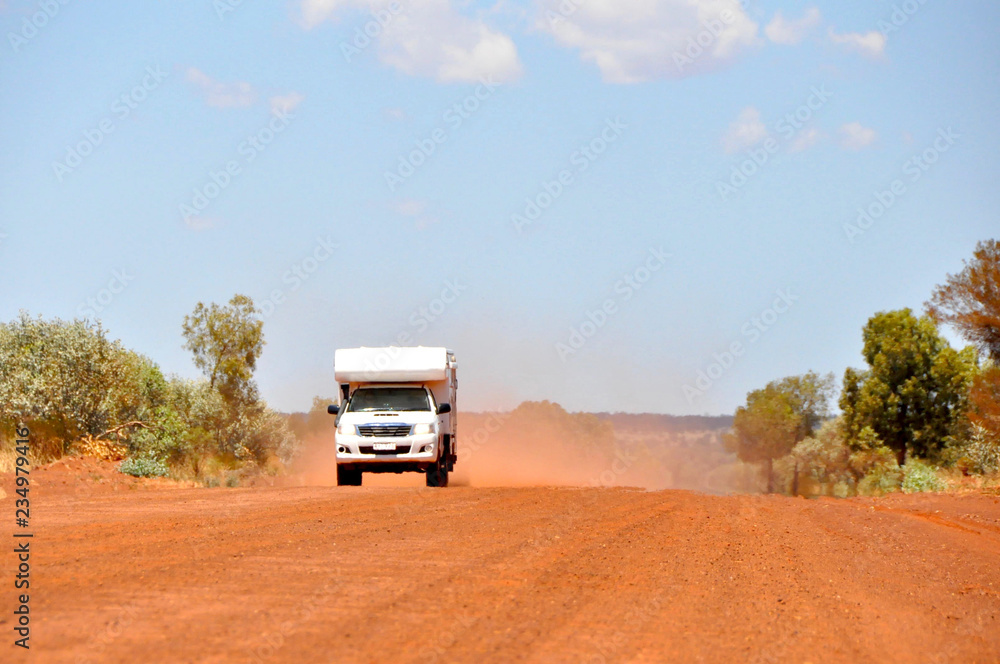 white 4x4 offroad pick up camper van approaching on red sand gravel ...