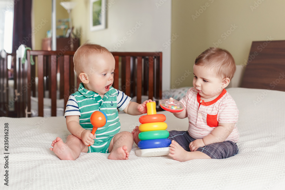 Group portrait of two white Caucasian cute funny baby boys sitting ...