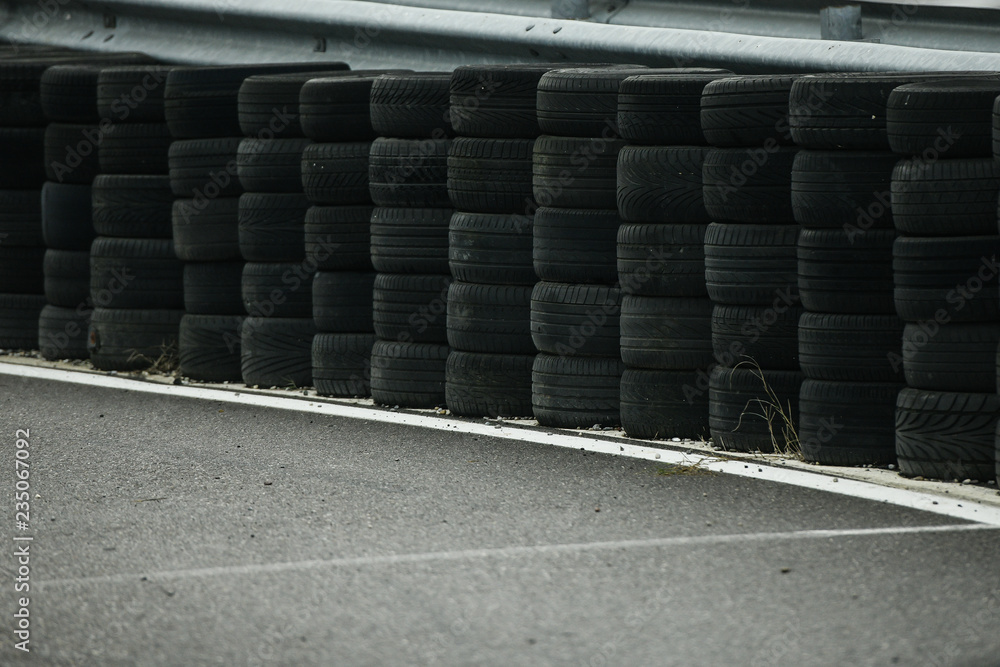 Stacked rubber tyres used on the side of a tarmac circuit curve as ...
