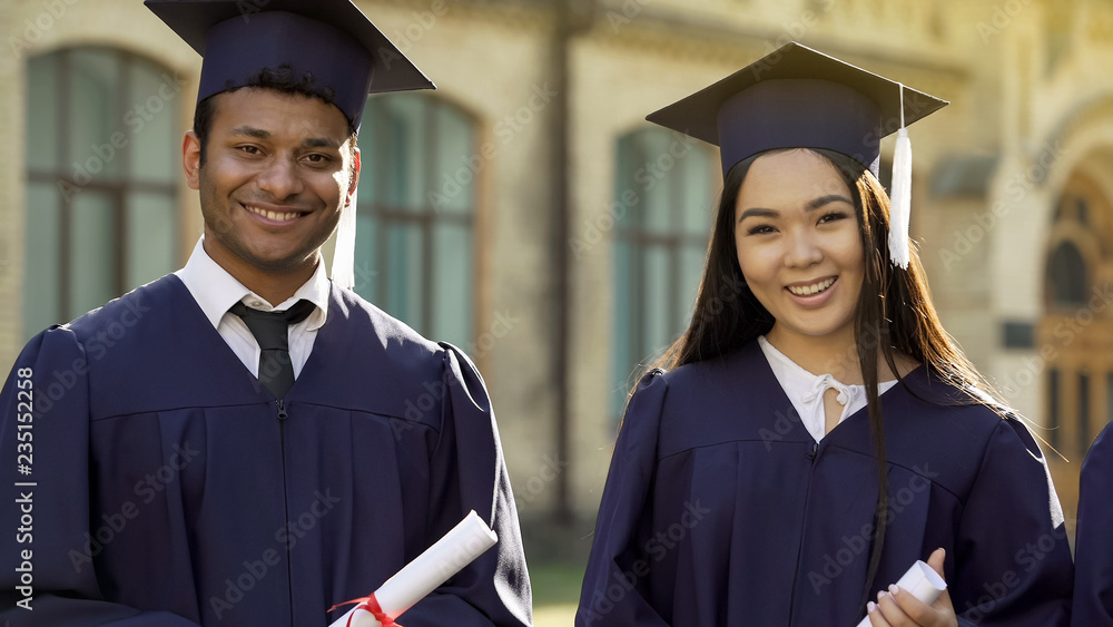 College student in graduation outfit with diplomas smiling, education ...