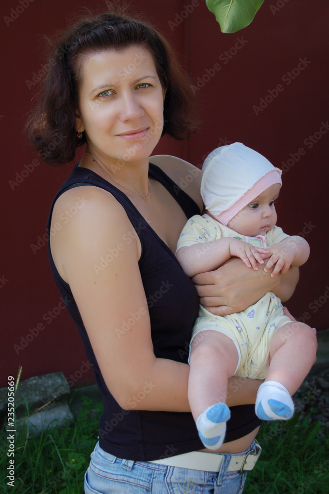 Beautiful young woman nursing with baby holding her on hands. A woman ...