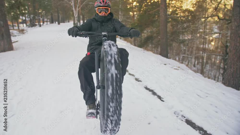 Professional extreme sportsman biker riding fat bike in outdoors ...