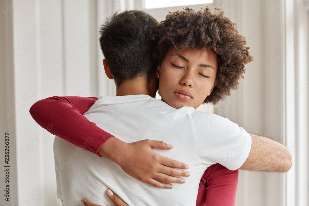 Friendly mixed race brother and sister embrace each other, support in ...