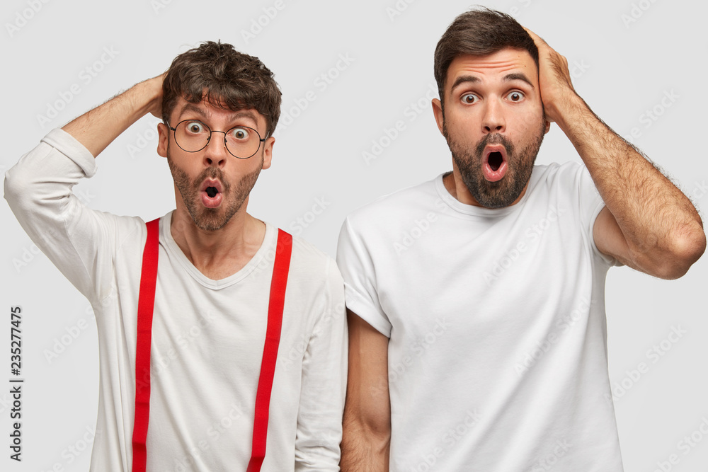 Stunned speechless impressed two guys stare with amazement, keep jaw ...