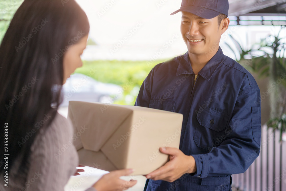 Fast and reliable service, Delivery man giving a cardboard box to young ...