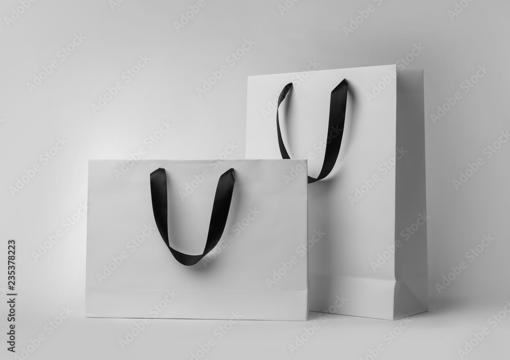 Paper shopping bags with ribbon handles on white background. Mockup for ...