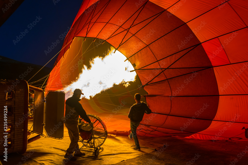 silhouette of a man with hot air balloons night time inflating Stock ...