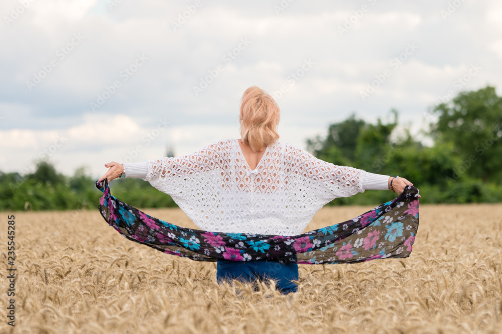 Back view of beautiful woman stand with spread arms, hold silk scarf ...