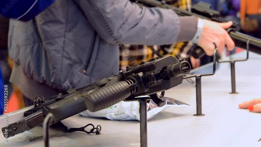 Weapon optics sight of sniper rifle with man close-up in store or shop ...