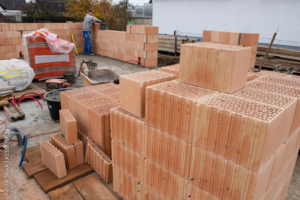 Maurer bauen eine Ziegelmauer an einem Rohbau foto de Stock | Adobe Stock