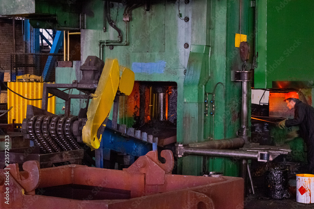 Hot iron in smeltery held by a worker. High precision hot forging ...