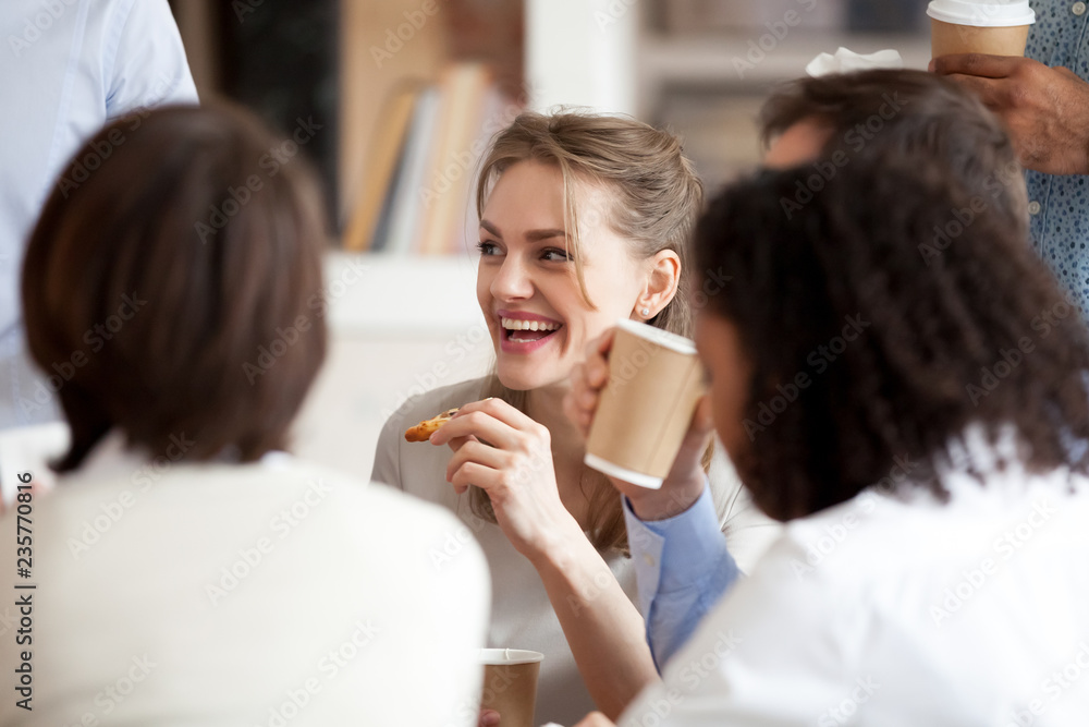 Smiling happy businesswoman eating pizza with multiracial colleagues on ...