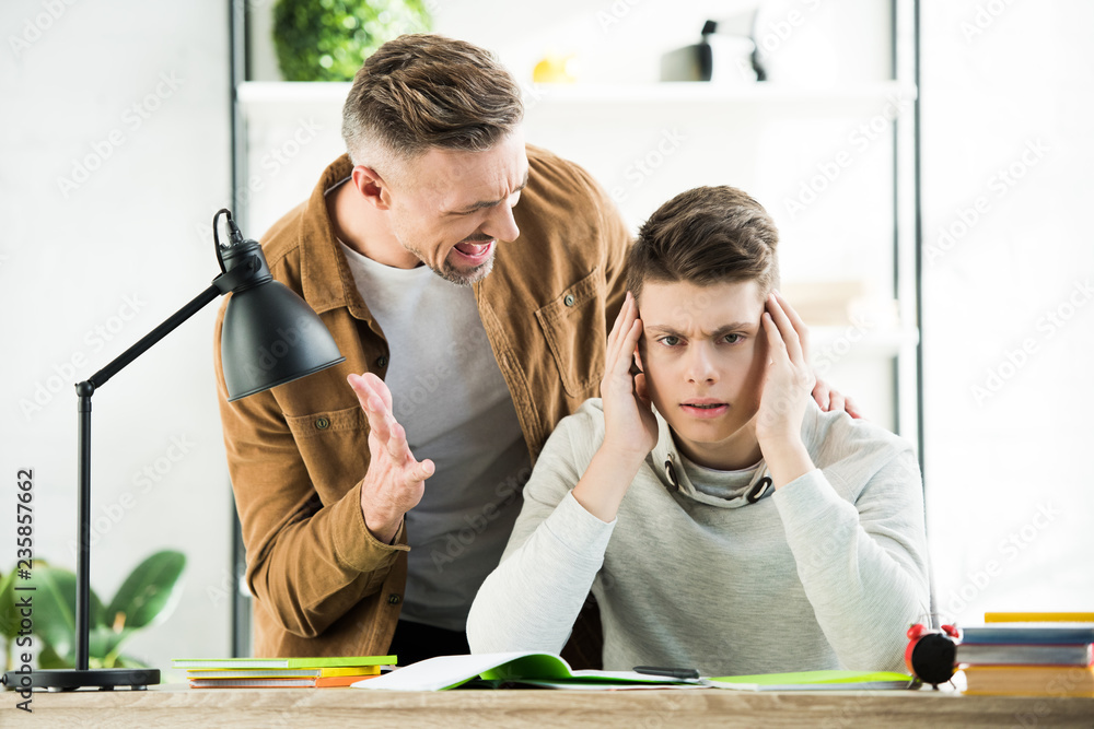 angry father screaming at teen son, boy covering ears Stock Photo ...