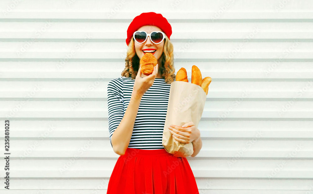 Portrait happy woman eating croissant holding paper bag with long white ...
