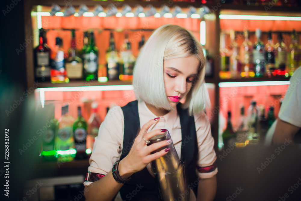 female bartender. girl with blonde hair. cocktail making in night bar ...