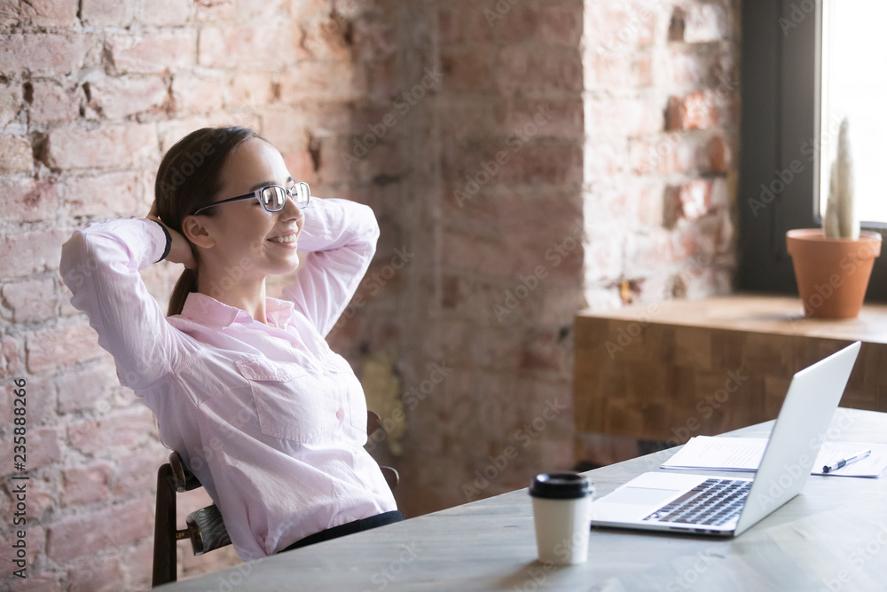 Satisfied woman relaxing leaning back in chair hands over head. Happy ...