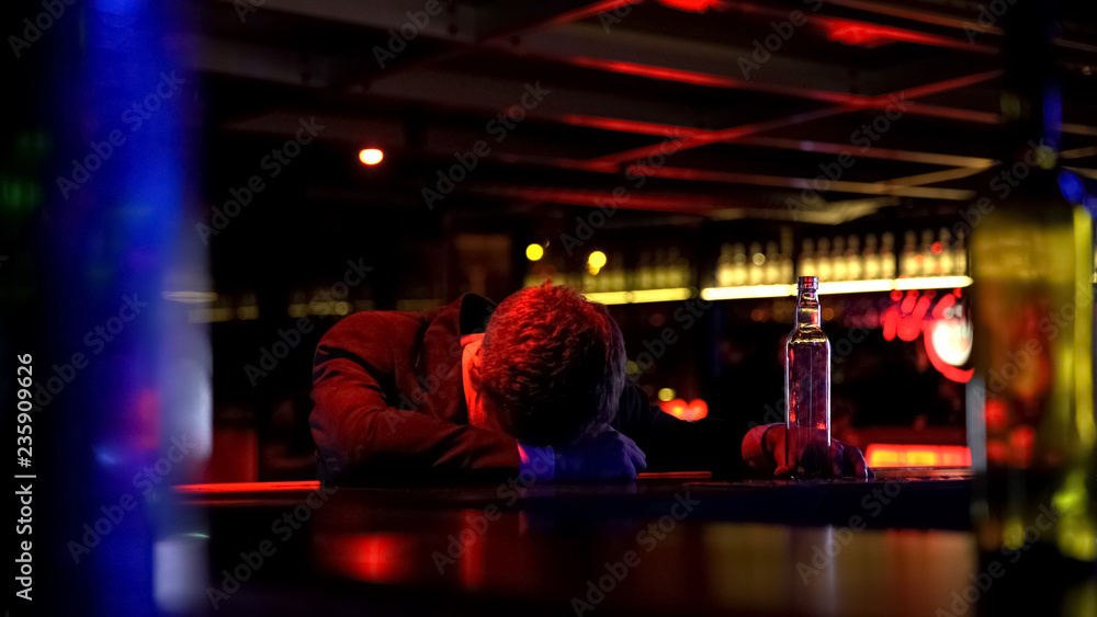 Alone drunk male stays late in night club, sleeping on bar corner ...