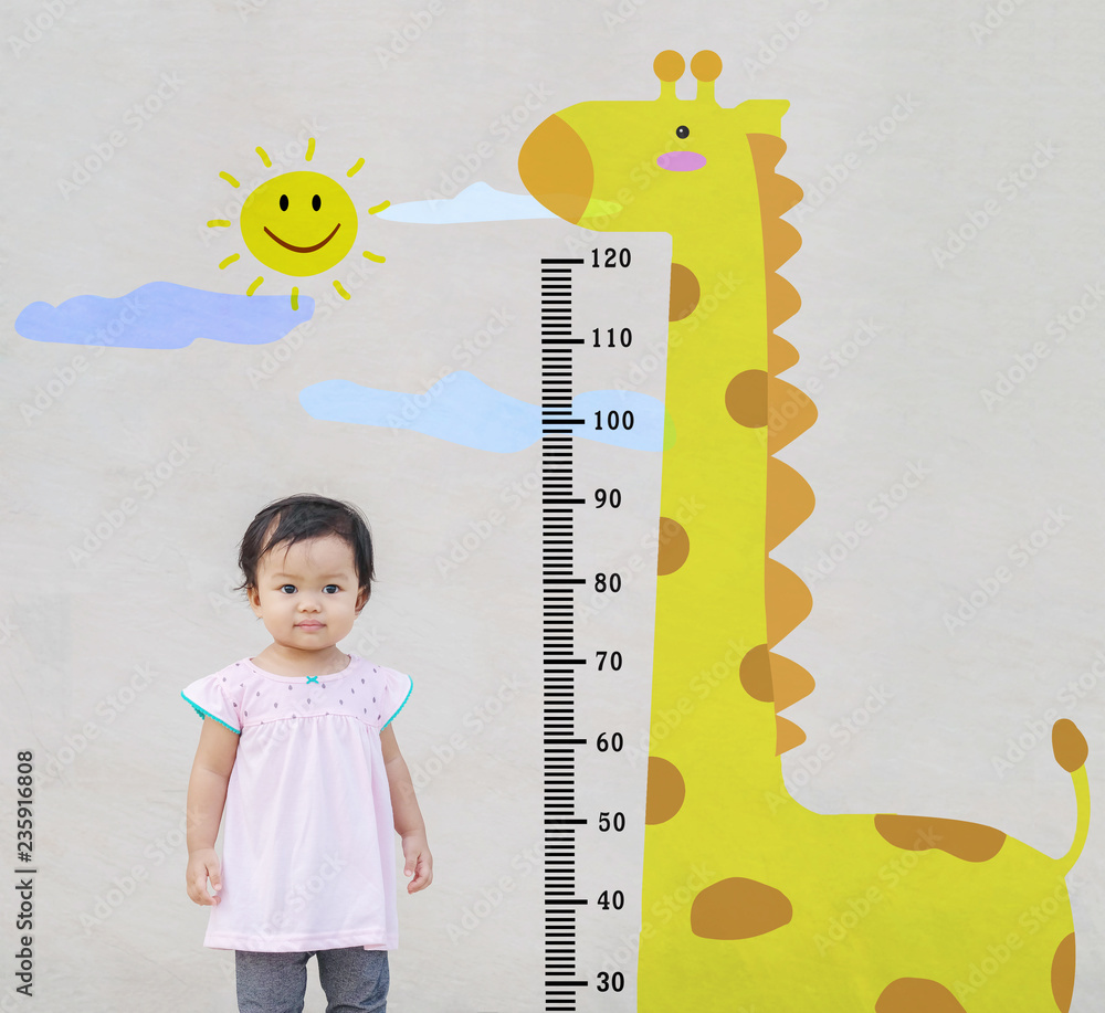 Closeup little girl stand for measure height with cute giraffe cartoon ...