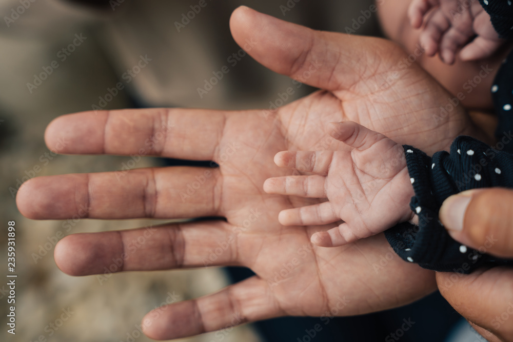 Comparing the size of a father's hand to his newborn baby's hand Stock ...