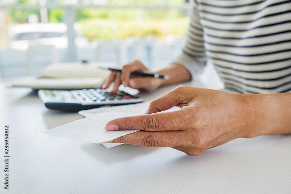 Woman with bills and calculator. Woman using calculator to calculate ...