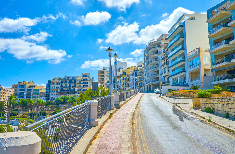 The line of modern seaside view buildings on the hills of Bugibba ...