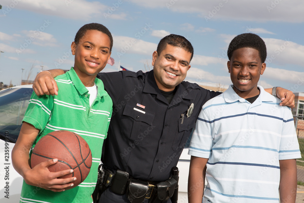 Policeman talking to kids on the street Stock Photo | Adobe Stock