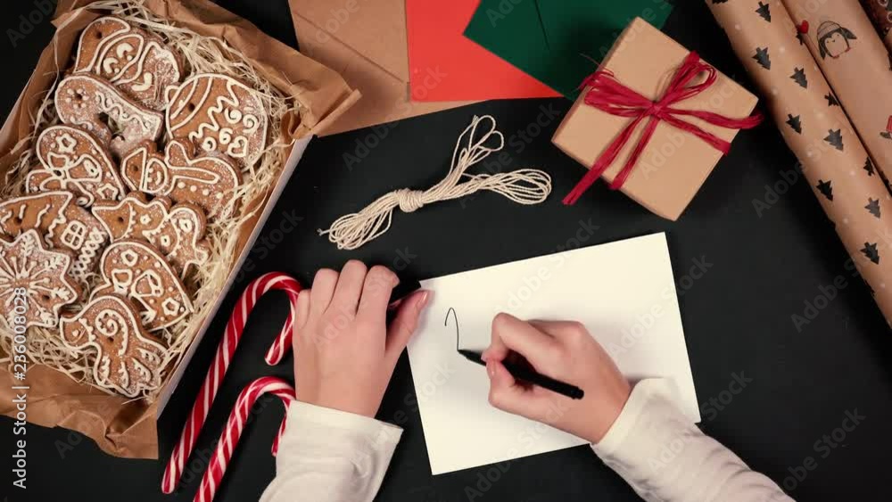 Woman writing on white paper sheet Merry Christmas text. Gingerbread ...