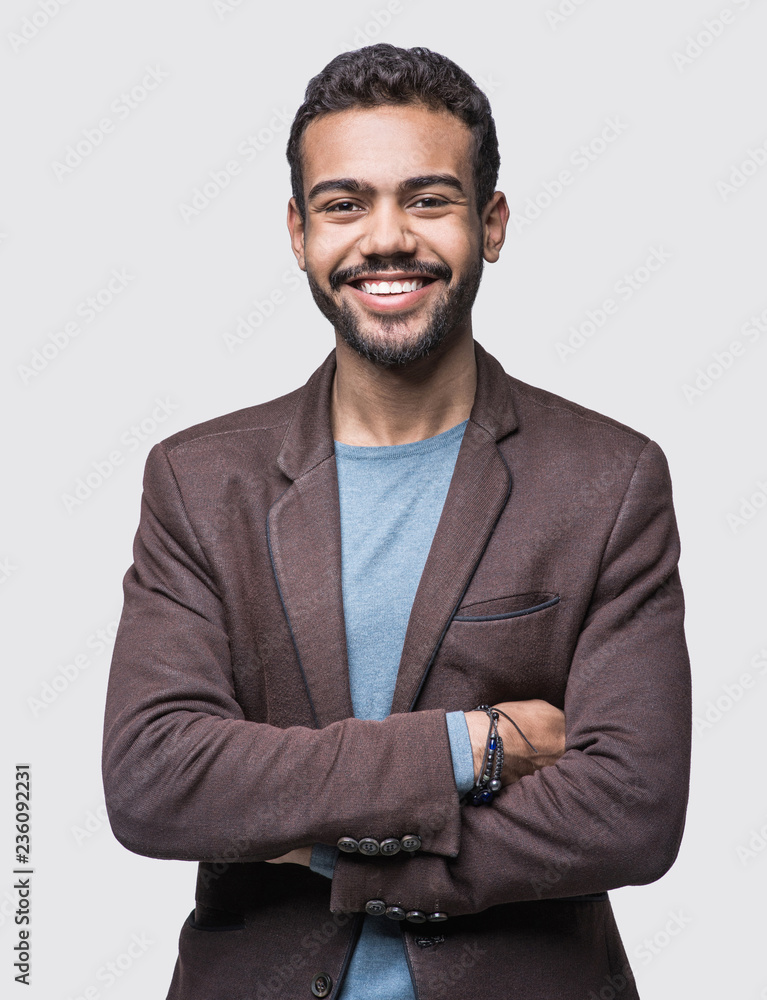 Portrait of handsome smiling young man with folded arms. Laughing ...