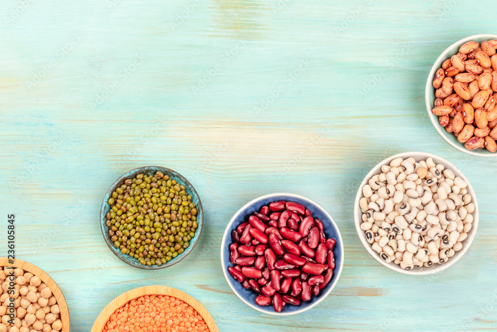 Various types of pulses, shot from the top on a teal background with a ...