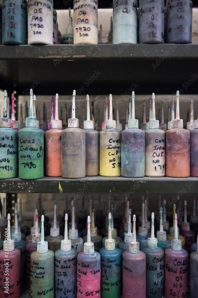 A shelf of Industrial fabric and wallpaper dye ink paint, in plastic ...