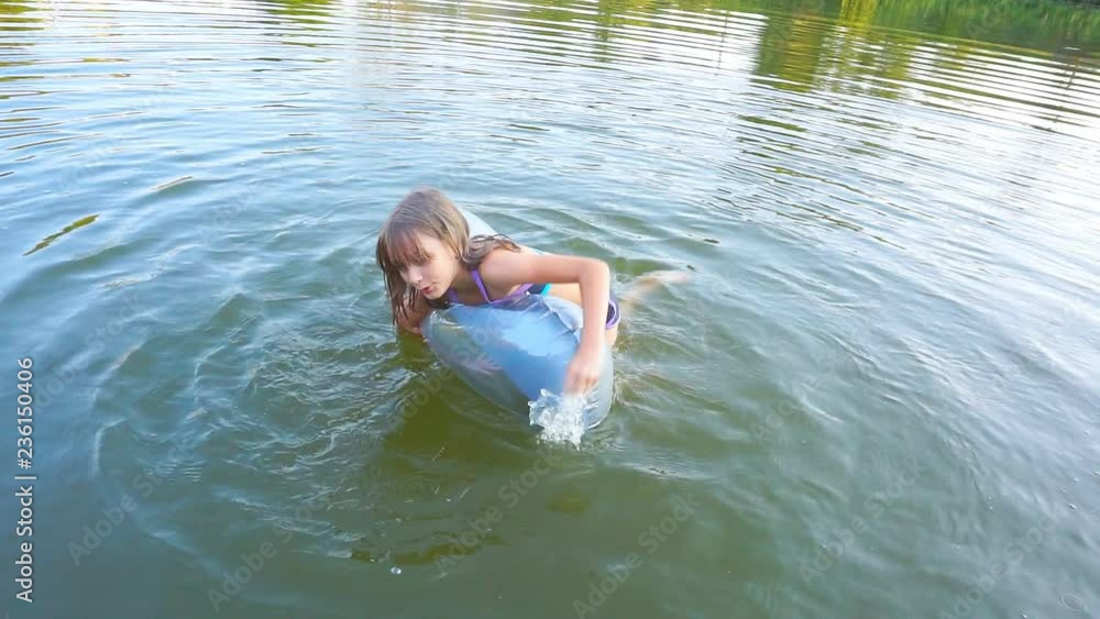 Little girl is swimming in a pond with an inflatable circle. 1920X1080 ...